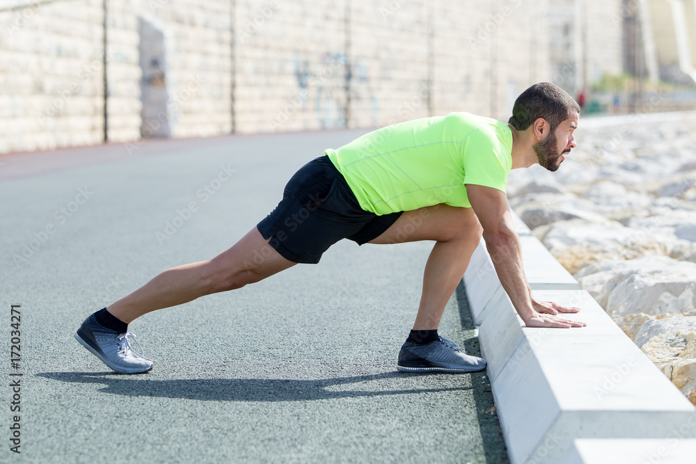 Strong Man Stretching Calf and Leaning on Curb Stock Photo | Adobe Stock