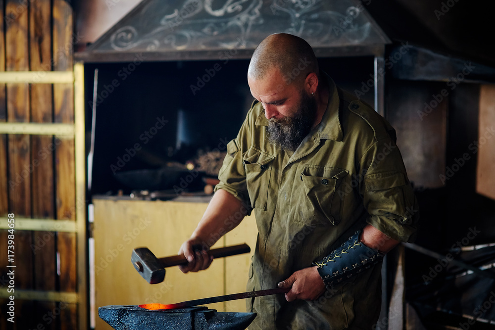 Blacksmith working in the forge. Manufacture of parts and weapons from ...
