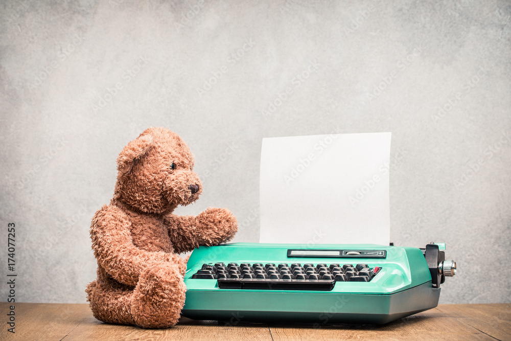 Retro Teddy Bear toy typing on old classic mint green typewriter with ...
