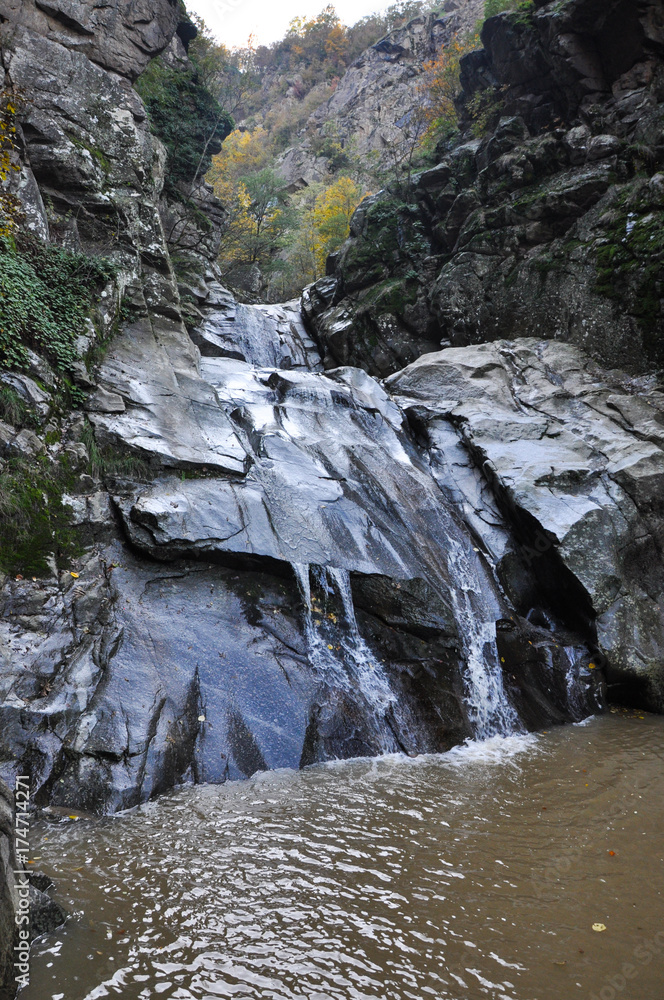 Landscape with a waterfall in a canyon, in the autumn. Small waterfall ...