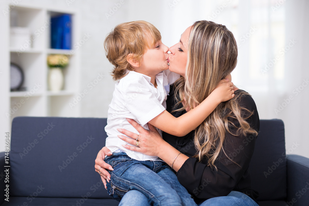 family portrait - young mother kissing her cute little son at home Stock Photo | Adobe Stock