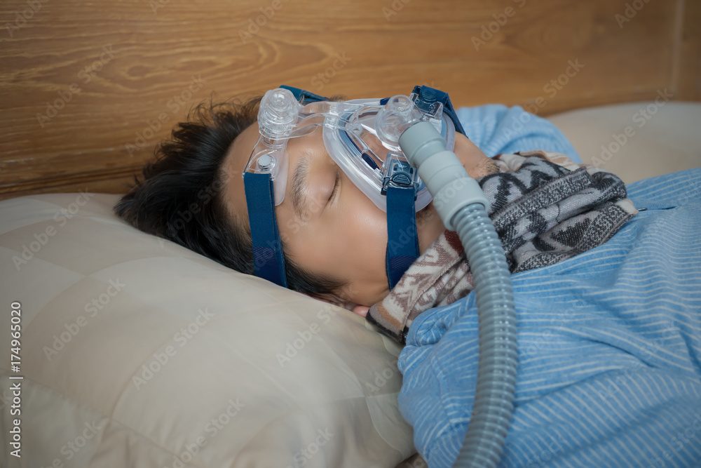 Man laying in bed wearing CPAP mask ,healthcare concept.Middle aged man ...
