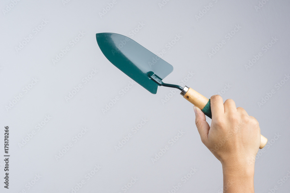 Hand holding green garden shovel with wooden handle Stock Photo | Adobe ...