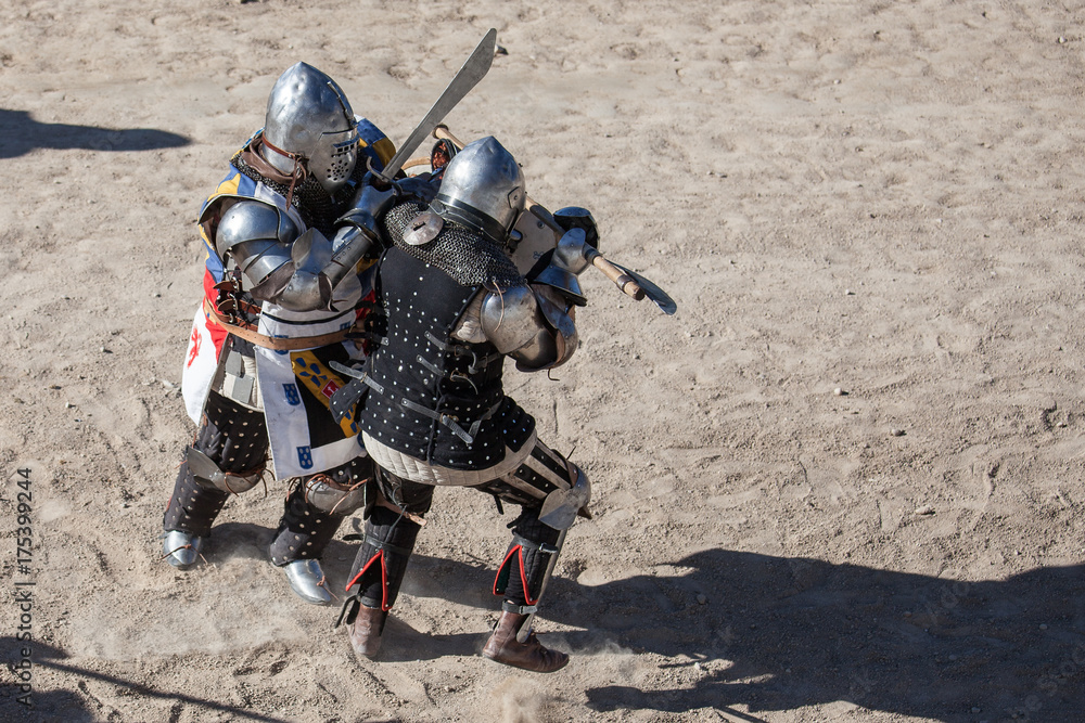 Men in a medieval battle. They are protected by armors from the 14th ...