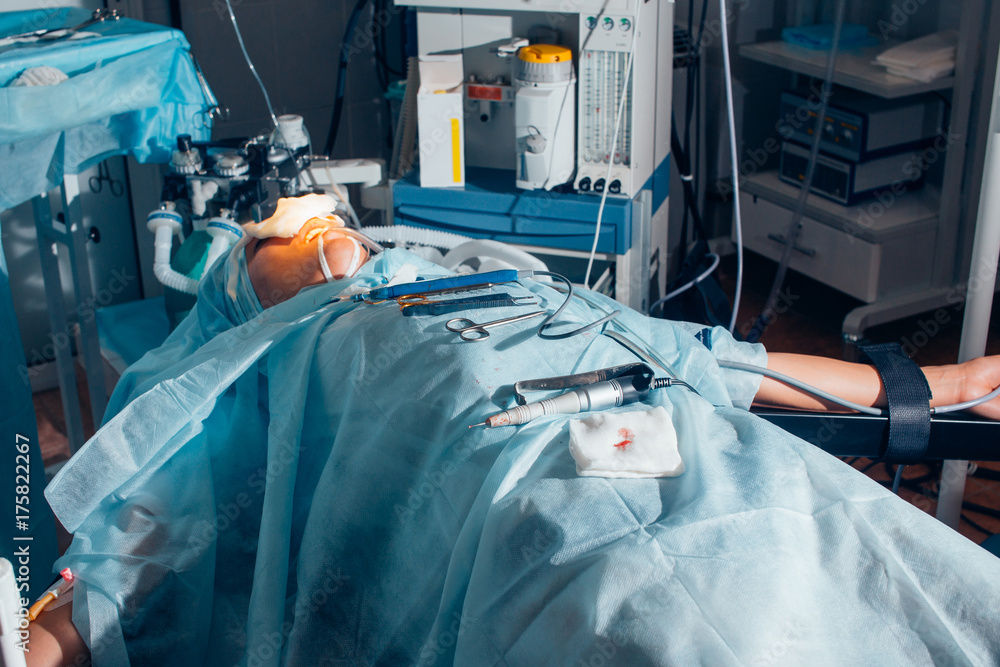 Horizontal shot of a female patient lying on operating table surgery ...
