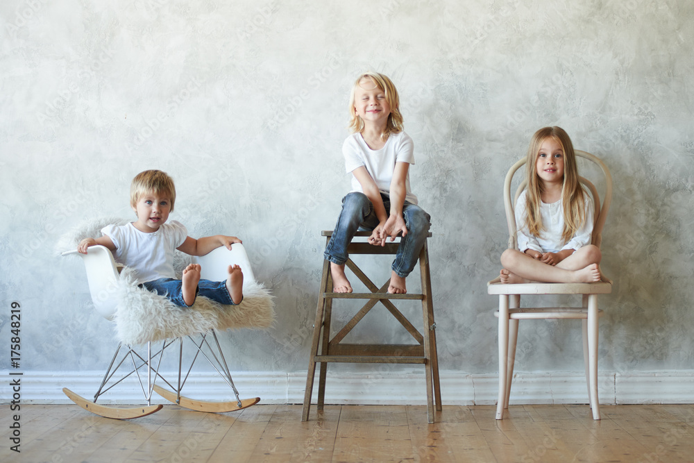 Funny children relaxing at home, playing indoor games while sitting on ...