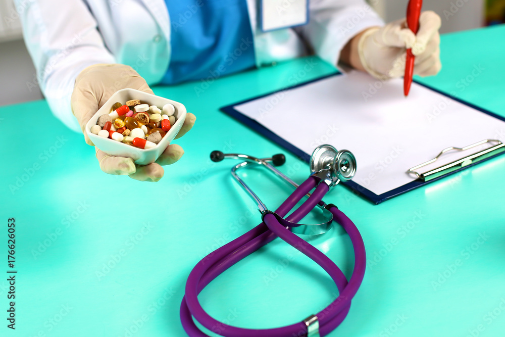 Female doctor hand hold pack of different tablet blisters at workplace ...