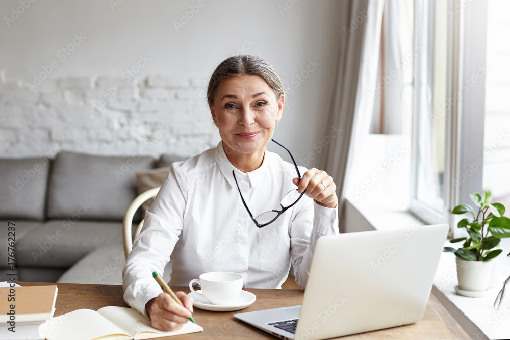 Cheerful skilled middle aged life or business coach enjoying creative ...