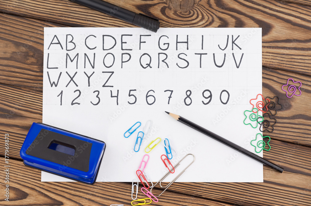 Handwritten capital letters and digits on white sheet and lot of ...