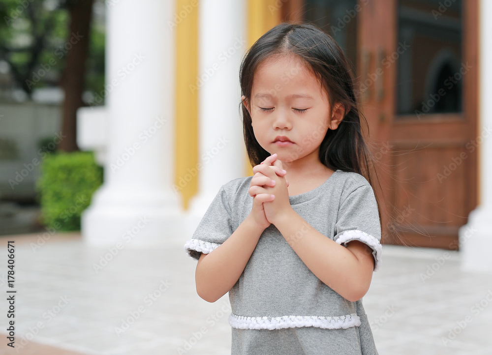 Little asian girl stance praying in the garden at the morning. Little ...