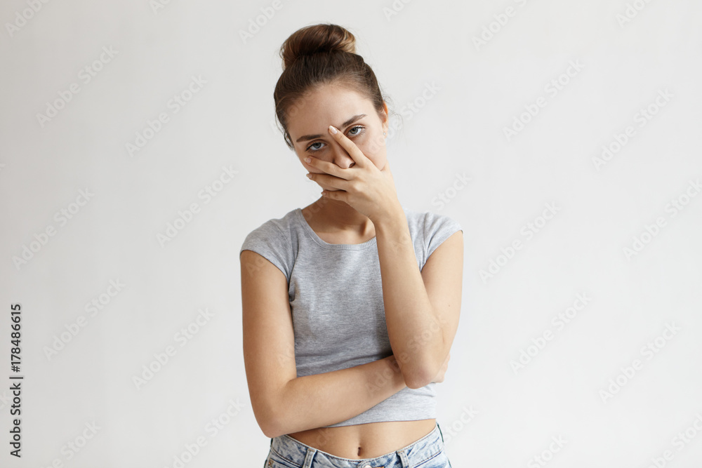 Portrait of annoyed stylish European girl wearing crop top with belly ...
