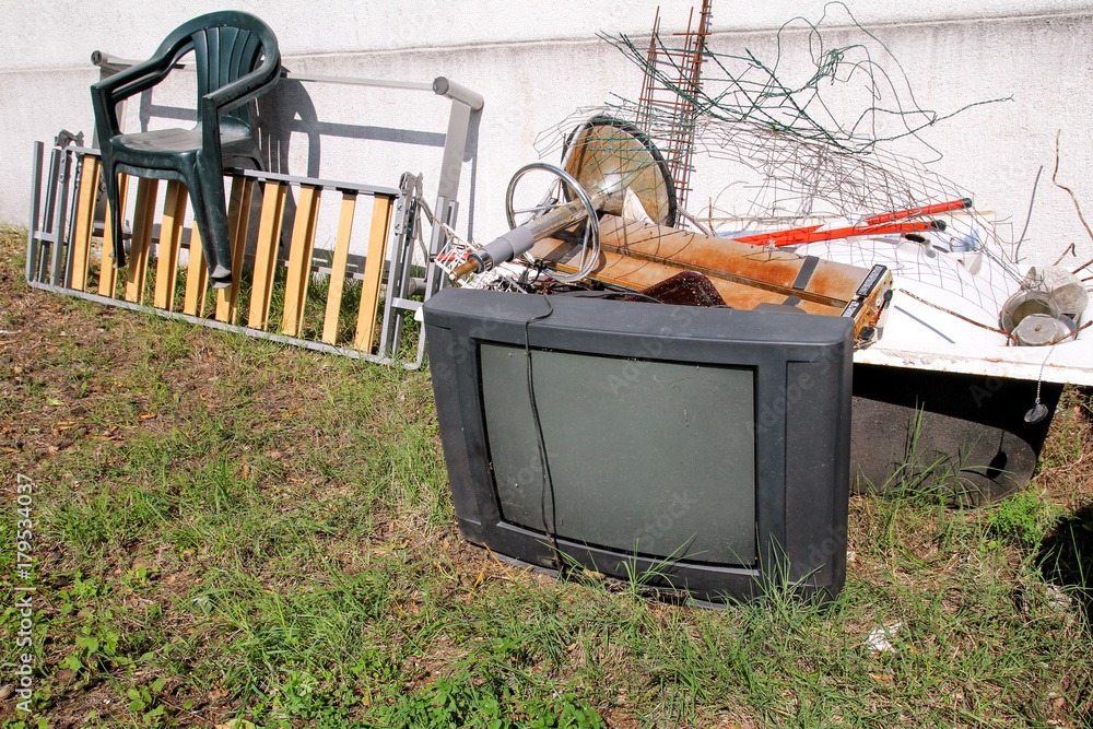 Green plastic garden chairs thrown away and left on a ladder by the ...