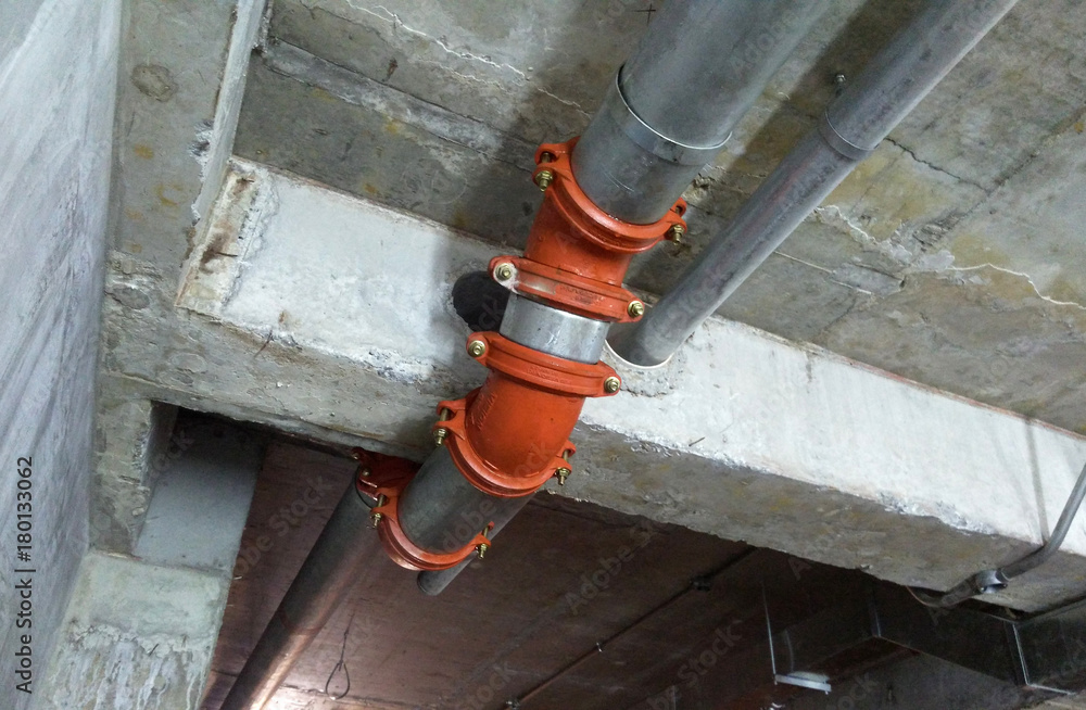 Sprinkler system pipe in hang at the slab soffit. Sprinkler is an ...