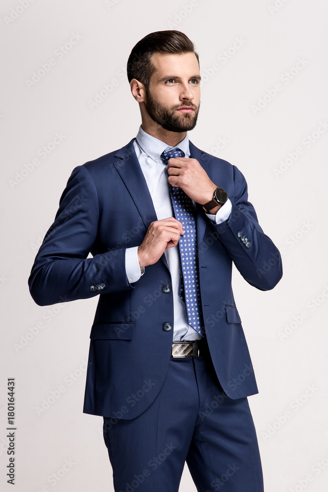 I will be on my suit and tie. Handsome young man adjusting his tie ...