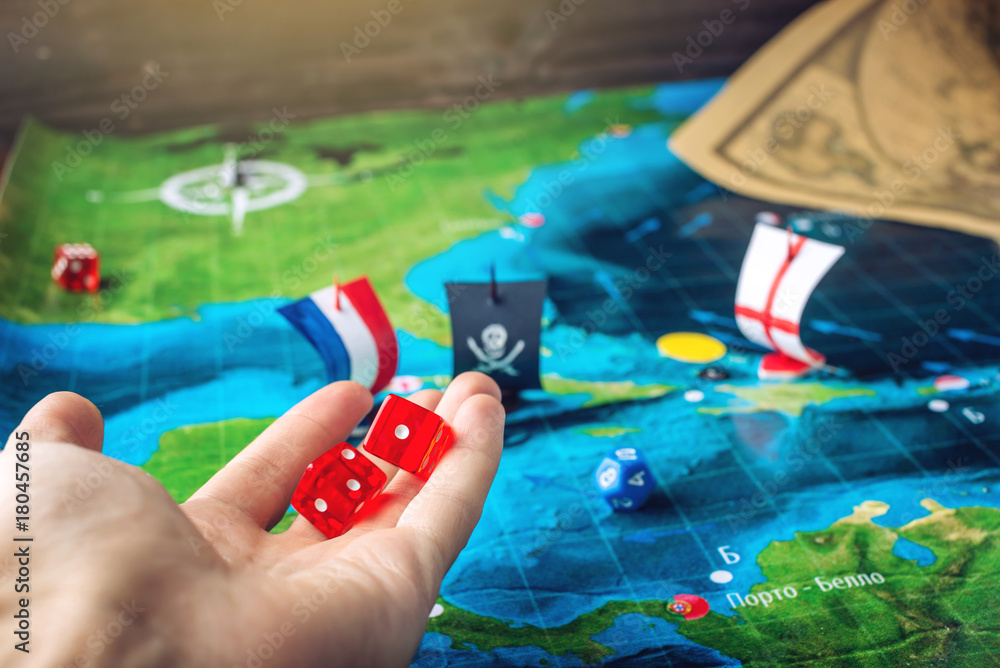 Hand throwing red dice on the world map of the playing field handmade ...