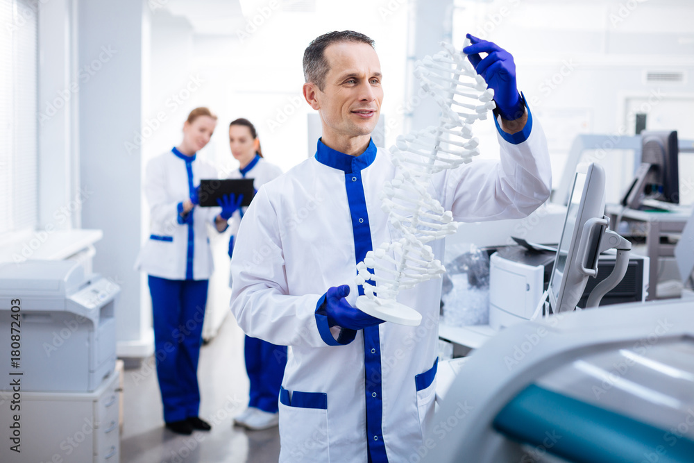 DNA mystery. Wistful happy male scientist carrying DNA and looking for ...