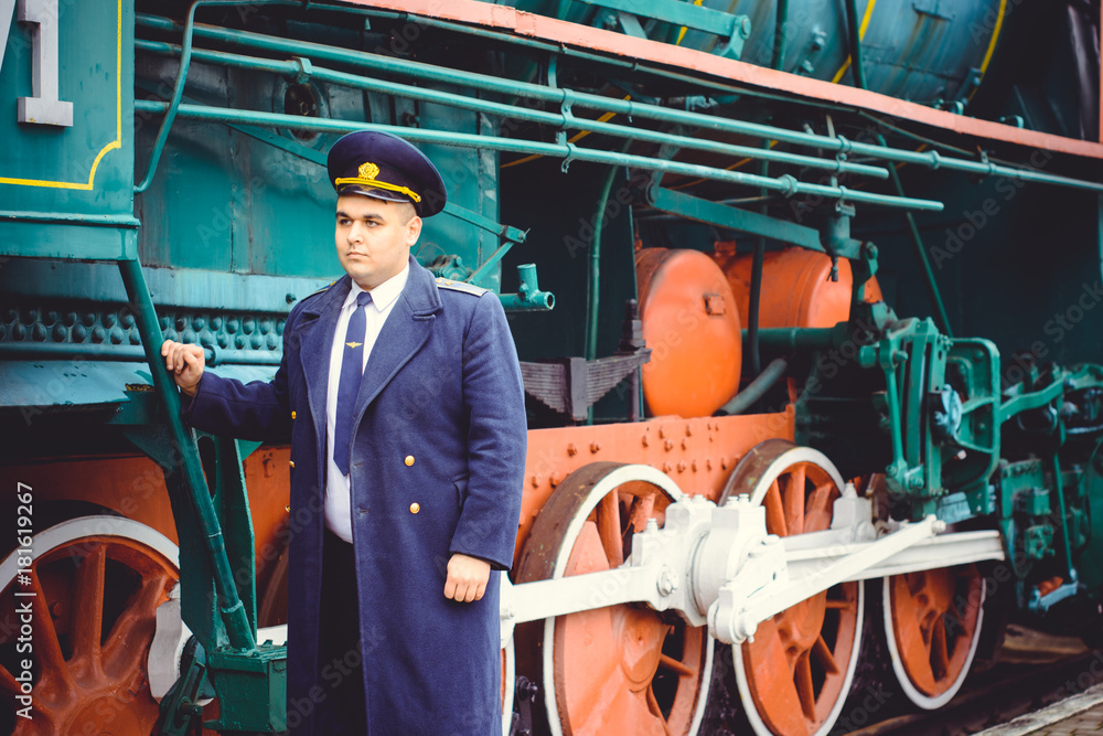 European or American train conductor is on his duty on a platform and ...