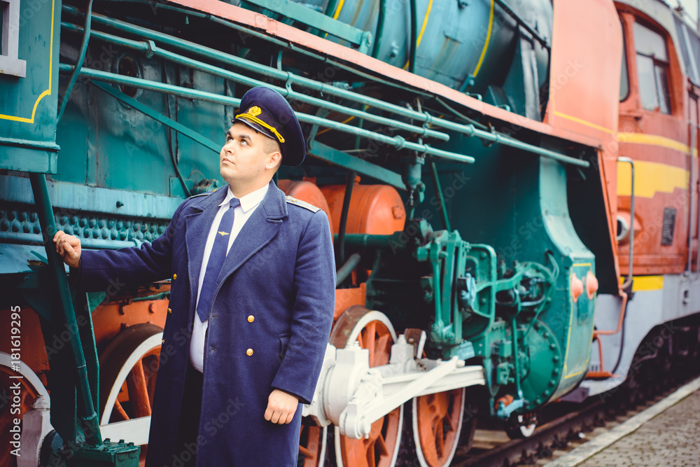European or American train conductor is on his duty on a platform and ...