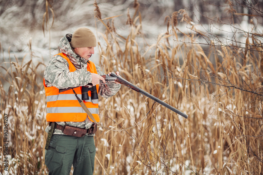 hunter loading rifle in a winter forest. Bushcraft, hunting and people ...