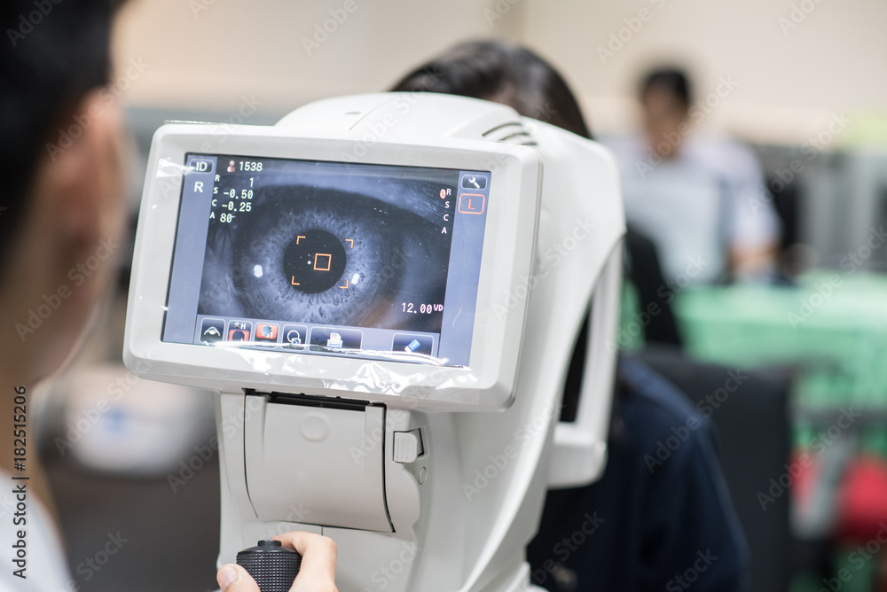 Woman looking at refractometer eye test machine in ophthalmology Stock ...