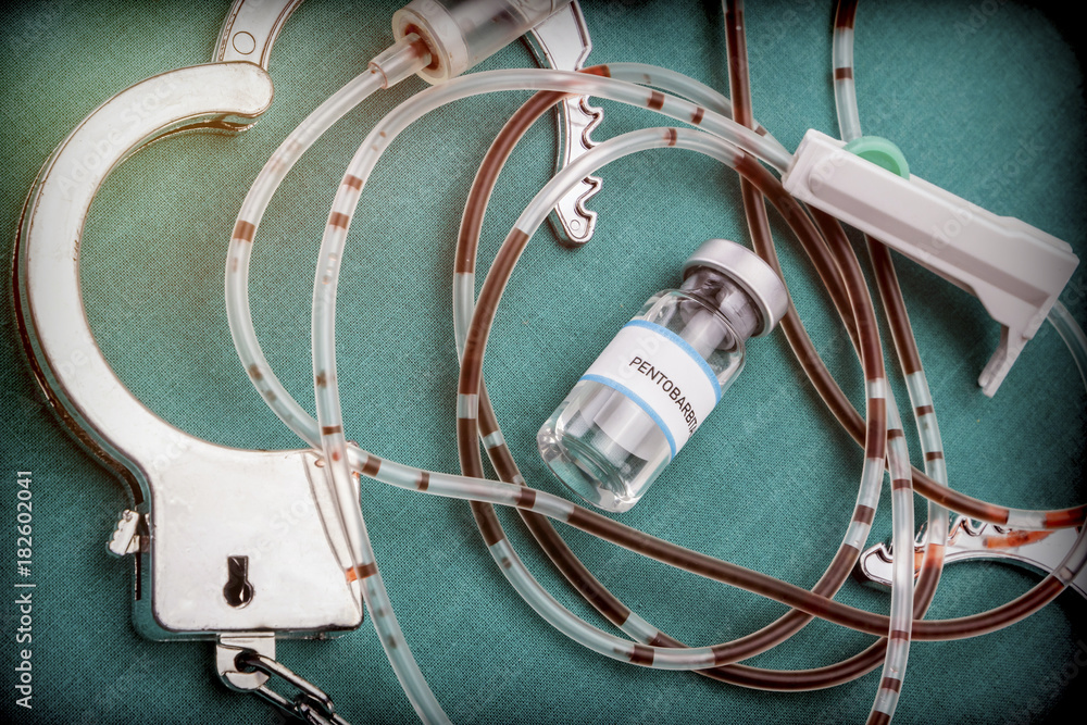 Handcuffs next to a vial of pentobarbital and drip irrigation equipment ...