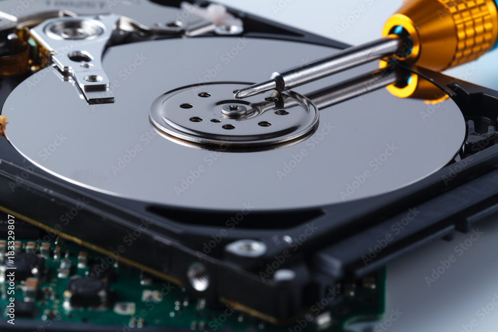 Used hard drive is opened, spindle is opening by a screw driver for ...