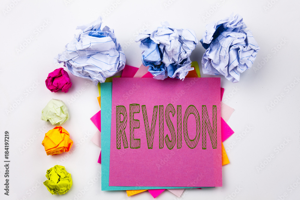 Writing text showing Revision written on sticky note in office with ...