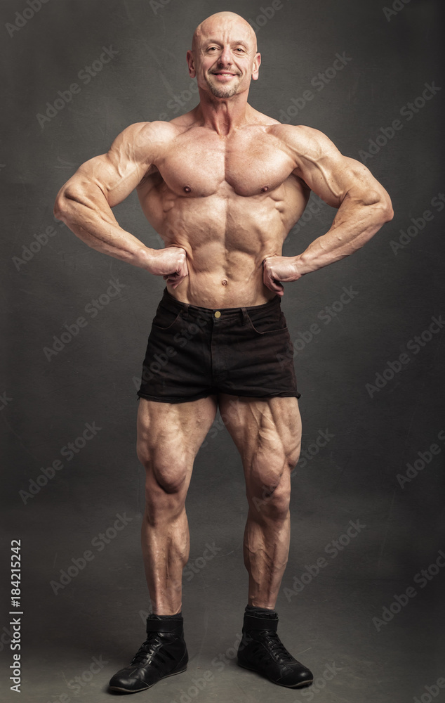 Athlete in front lat spread pose. Bodybuilder showing muscles on studio ...