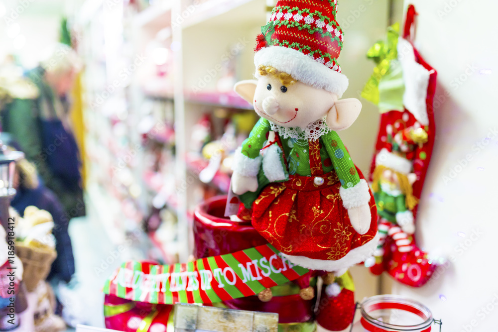 Handcrafted fabric Christmas elf toy with woollen hat hanging in a shop ...