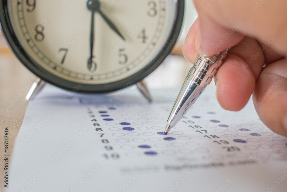 Students taking optical form of standardized exams near Alarm clock ...