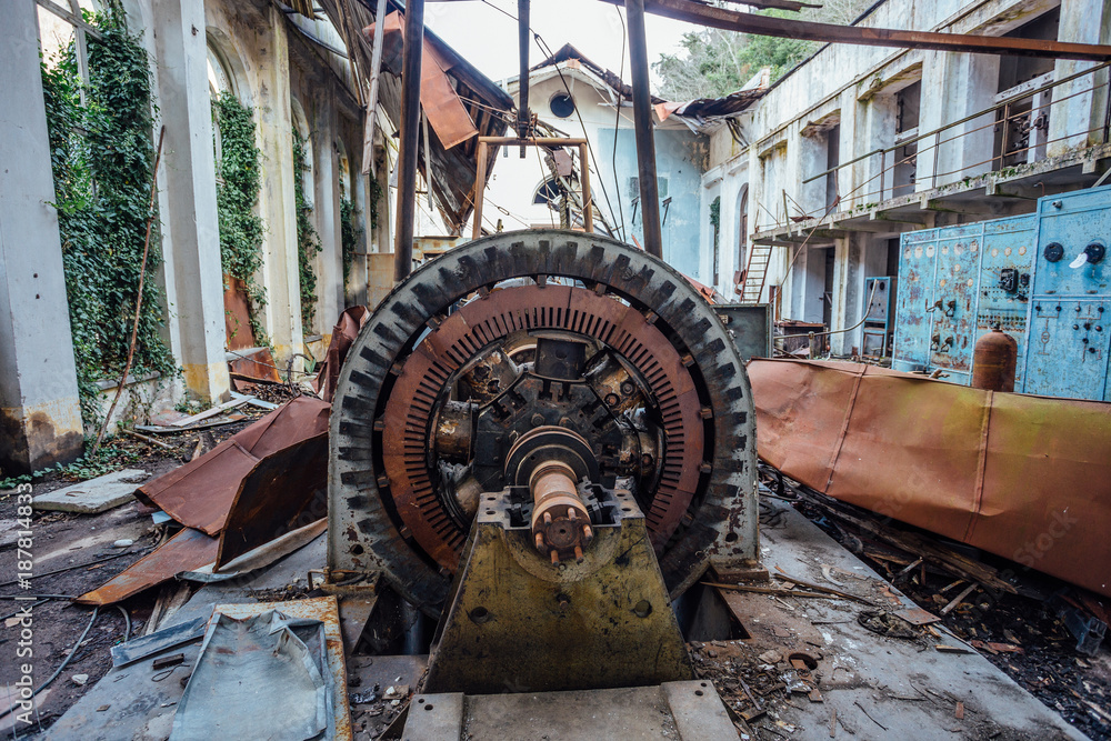 Ruined abandoned hydroelectric power plant. Rusty generator at ...