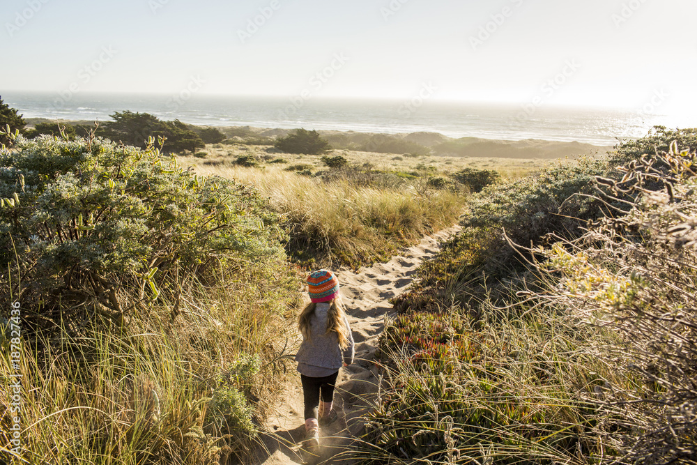 Caucasian girl walking on sandy path Stock Photo | Adobe Stock