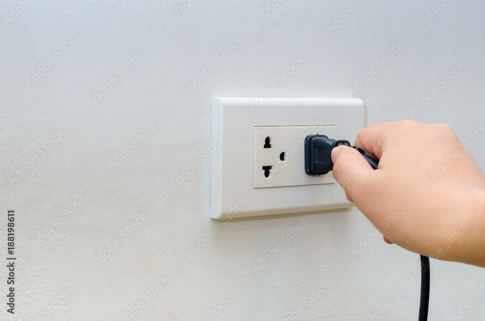 hand outlet Power saving Hand inserting electrical plug into outlet ...