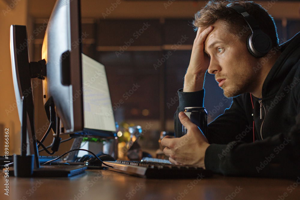 What is it. Side view surprised unshaven man watching at display of ...