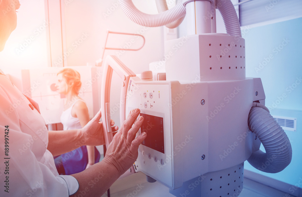 Radiologist and patient in a x-ray room. Classic ceiling-mounted x-ray ...