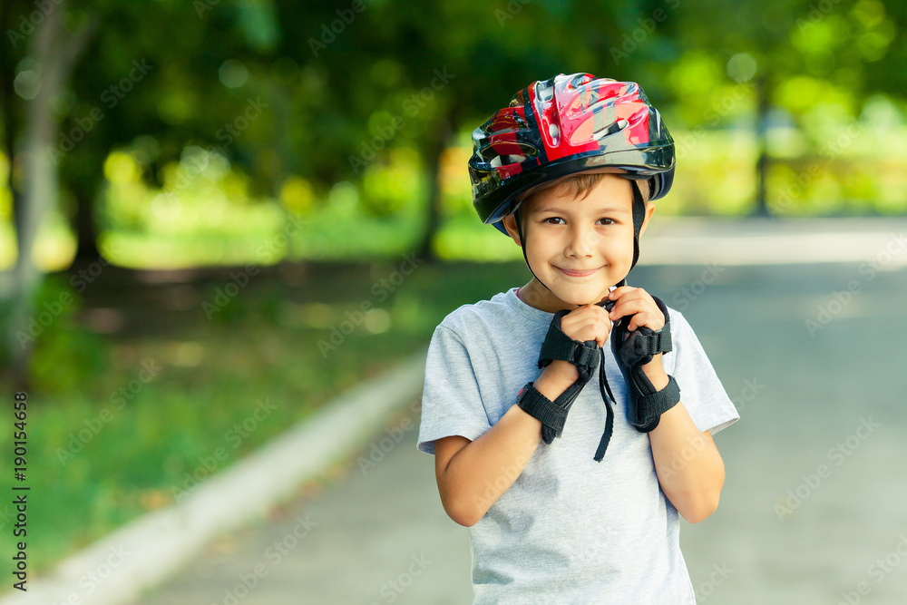 Little boy riding on rollers in the summer in the Park. Happy child in ...