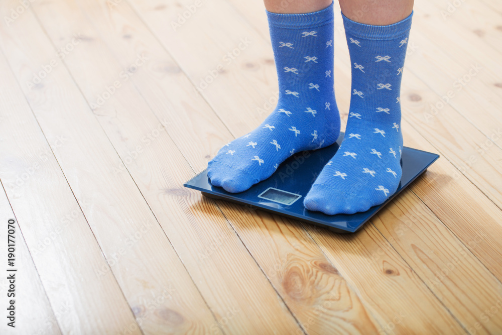 female feet in socks on the floor scales Stock Photo | Adobe Stock