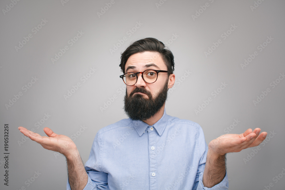 Foto Confused man holding hands apart do Stock | Adobe Stock