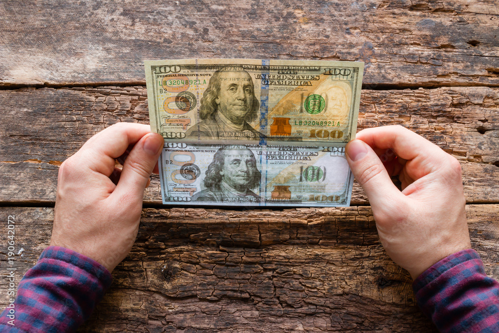 man shows the difference between an authentic and fake banknote Stock ...