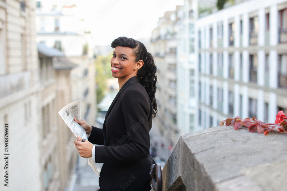 Foto Young reporter looking at cam with newspaper on balcony near high ...