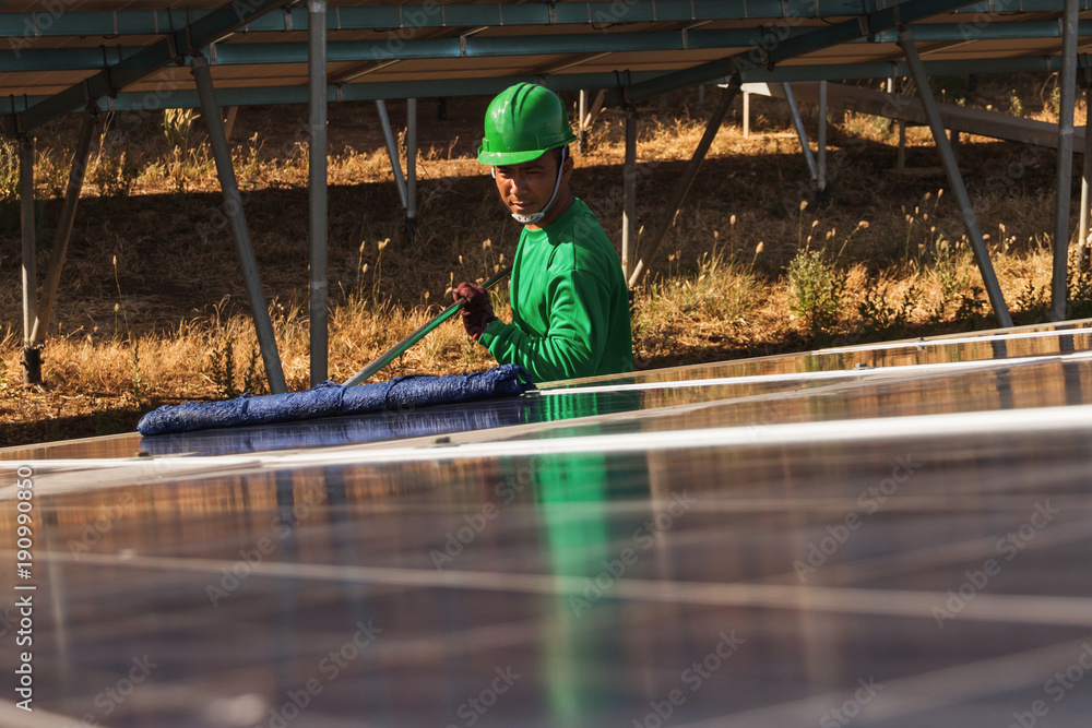 labor working on cleaning solar panel at solar power plant; operation ...