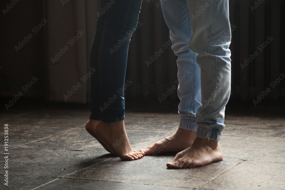 Barefoot girl standing on tiptoe to hug her man at home, sweet cute ...