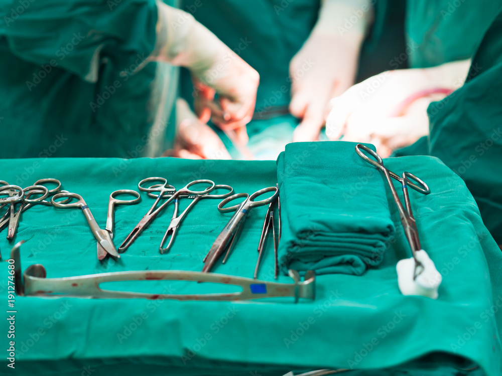 Sterile surgical tools, clamps, incisor, dilators on surgical tray with ...