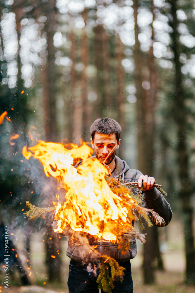 Happy funny crazy fearless man holding burning firewood in hands ...