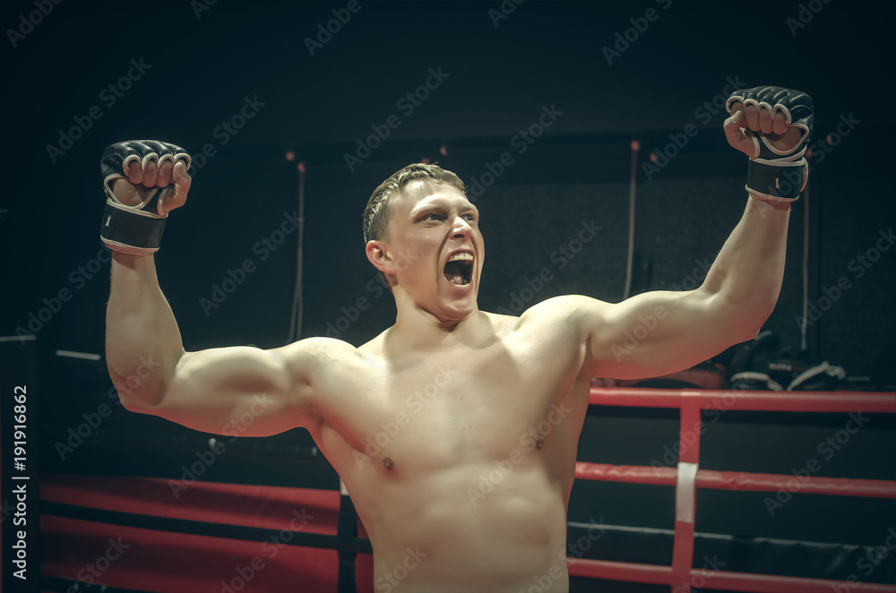Angry and aggressive fighter shows his superiority by holding his hands ...