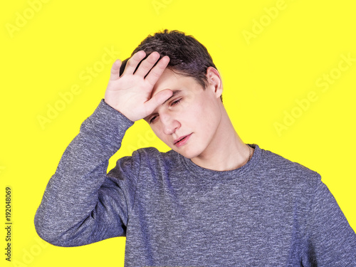 A tired man stressed sweating with a headache fever isolated against a ...