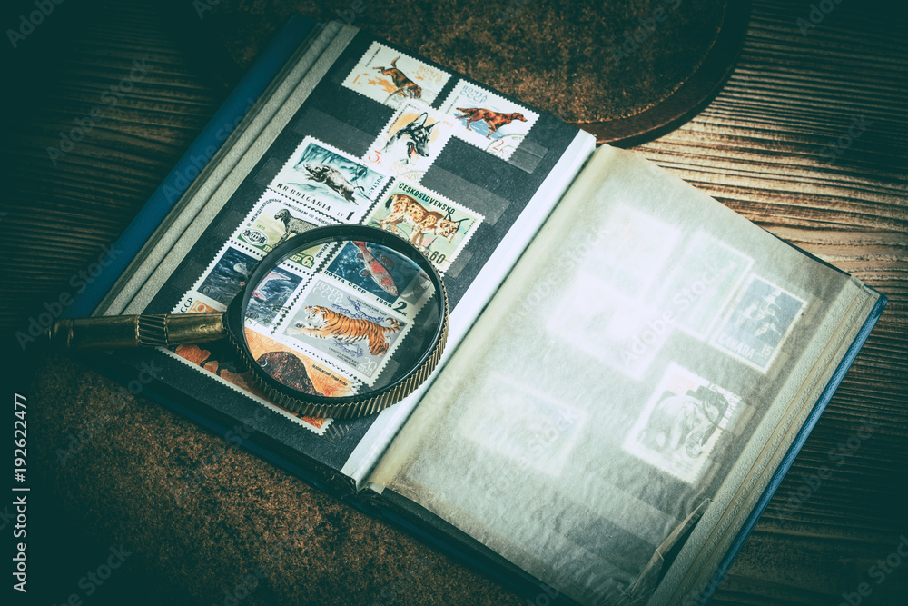 Book with postage stamps and a magnifying glass. Vintage style. Stock ...