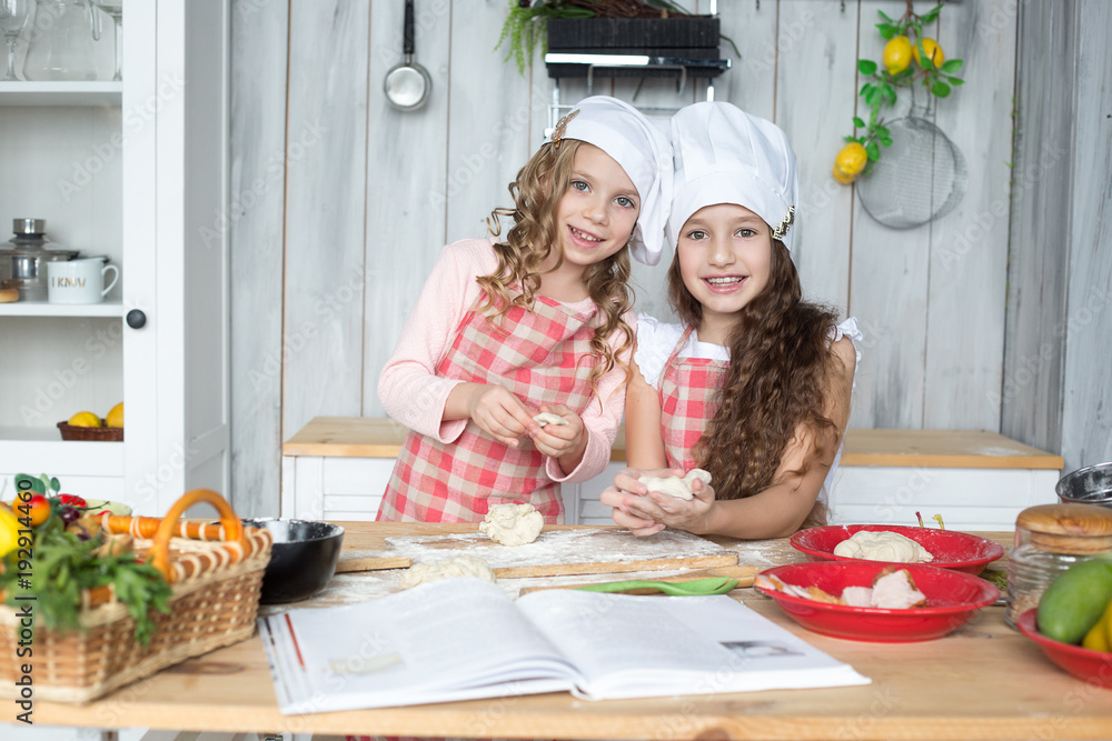 Girls, sisters, girlfriends, children prepare food in the kitchen ...