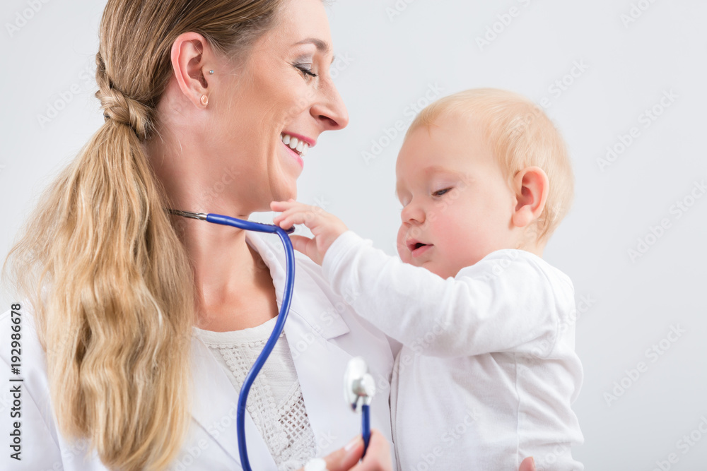 Portrait of a dedicated female physician and pediatric care specialist, smiling while holding a ...
