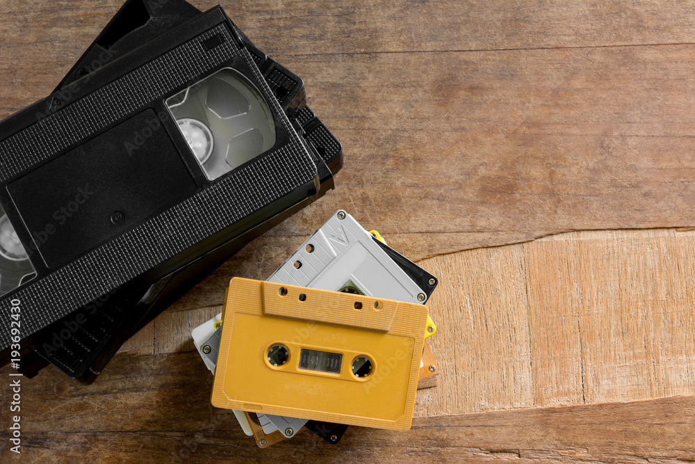 stack of old cassette and video tape on wooden board with copy space ...